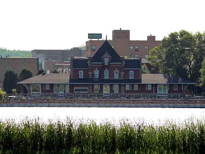 Historic waterfront buildings reflect in calm waters, creating scenes that belong on a Norman Rockwell canvas.