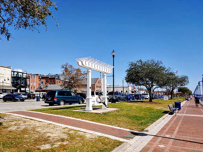 That white pergola and riverside walkway create the perfect spot for watching the world slow down.