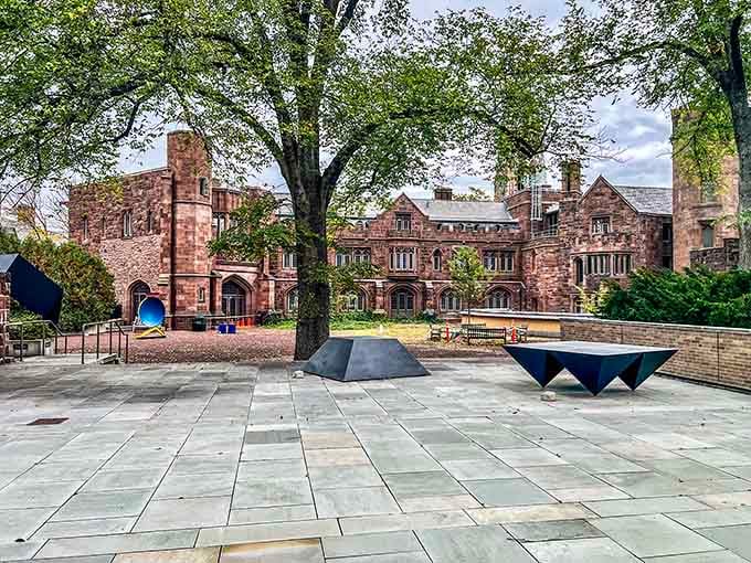 Yale's historic architecture frames a modern plaza where students and art lovers cross paths beneath towering academic buildings.