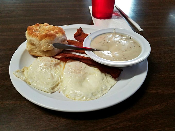 Two perfectly cooked eggs with bacon, biscuits, and gravy represent everything right about Southern breakfast traditions.