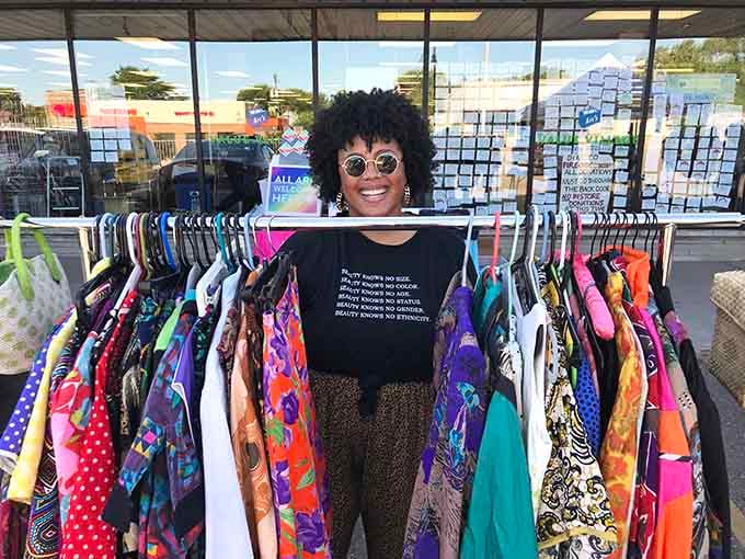 Pure joy radiates from a shopper surrounded by colorful finds, proving thrift shopping is truly a contact sport.