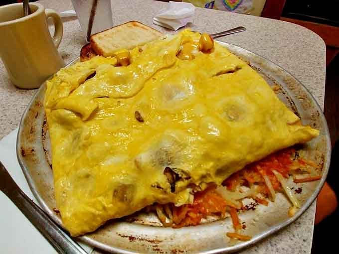 Behold the twelve-egg legend on its pizza pan throne, making regular omelets look like appetizers everywhere.