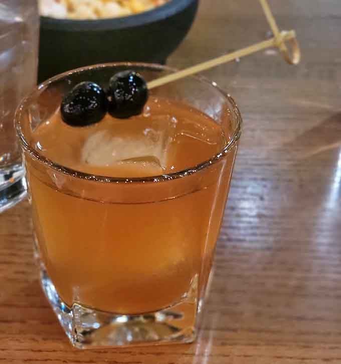 An Old Fashioned garnished with cherries that looks like it was mixed by someone who actually respects the craft.