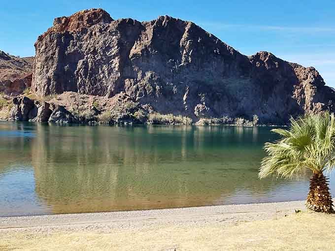 That towering rock formation rising from turquoise water creates a scene worthy of a vintage travel poster from the golden age.