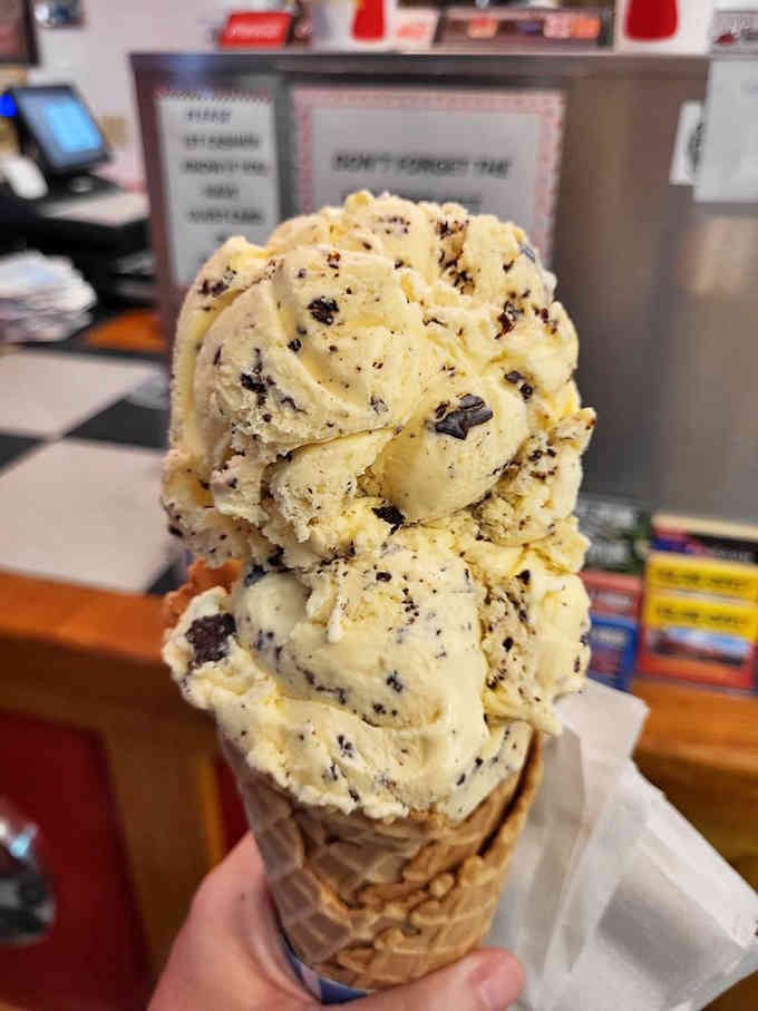 Three scoops of cookies and cream stacked in a waffle cone: because subtlety is overrated when ice cream's involved.