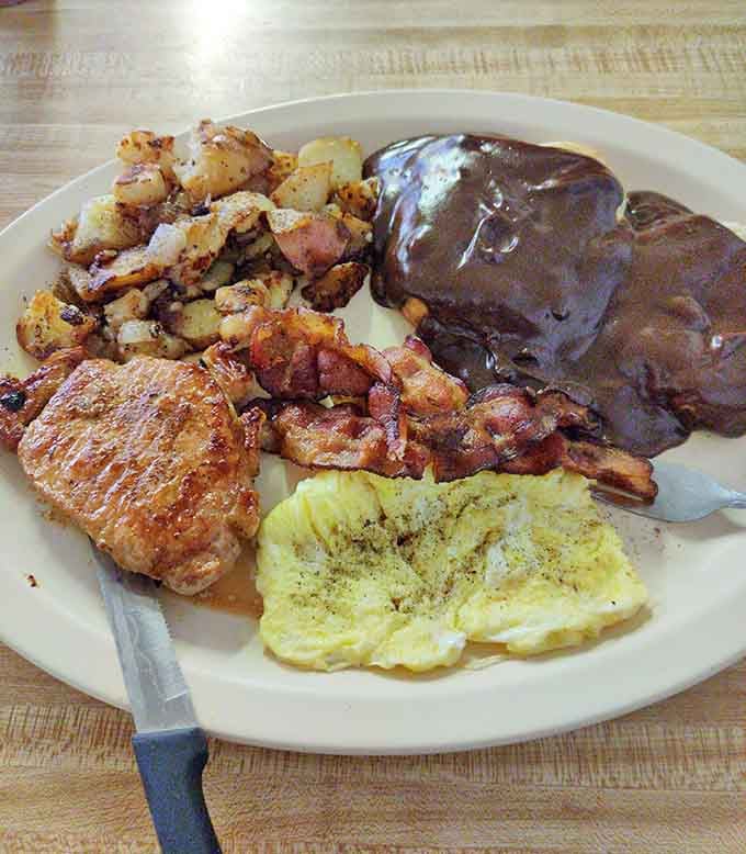 Behold the Hungry Man Platter in all its glory, complete with pork chop, eggs, home fries, and chocolate gravy bliss.