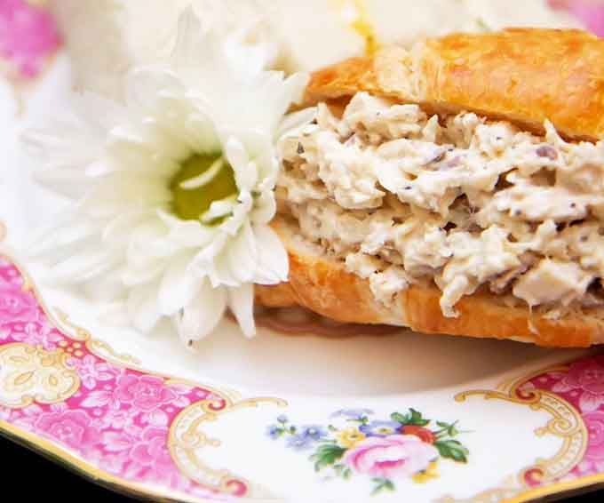 This isn't your average sandwich; it's a croissant stuffed with chicken salad dreams and garnished with pure elegance.