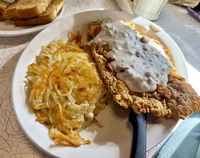Chicken fried steak smothered in gravy with hash browns, because sometimes breakfast needs to be taken seriously.