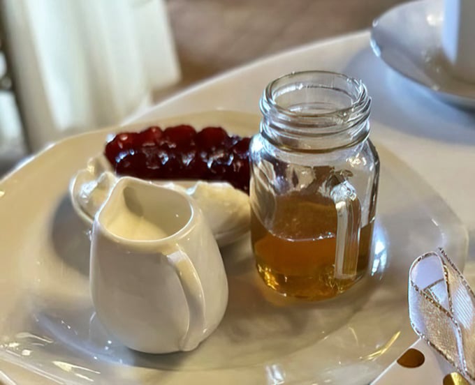 Clotted cream and jam await their scone destiny, the holy trinity of teatime perfection.