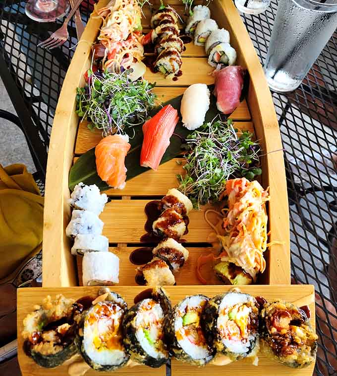 This sushi boat presentation is basically the Titanic, except everyone's happy and nothing sinks except your willpower around all those gorgeous rolls.