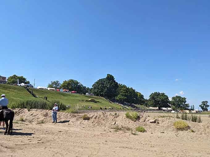 Rolling hills frame the beach where D-Day reenactments transform peaceful shores into living history lessons each August annually.