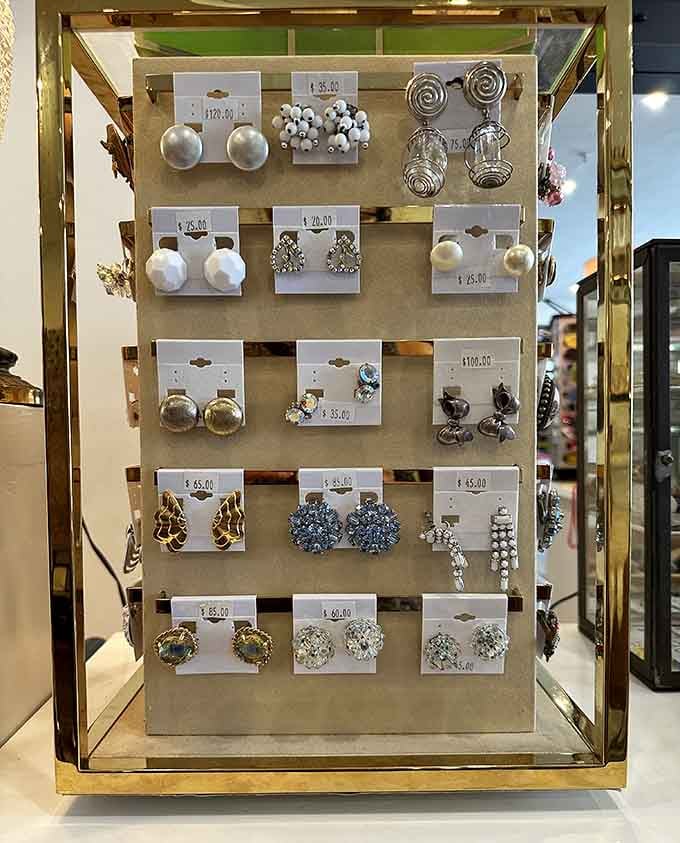 Statement earrings displayed like crown jewels, proving secondhand doesn't mean second-rate in any universe.