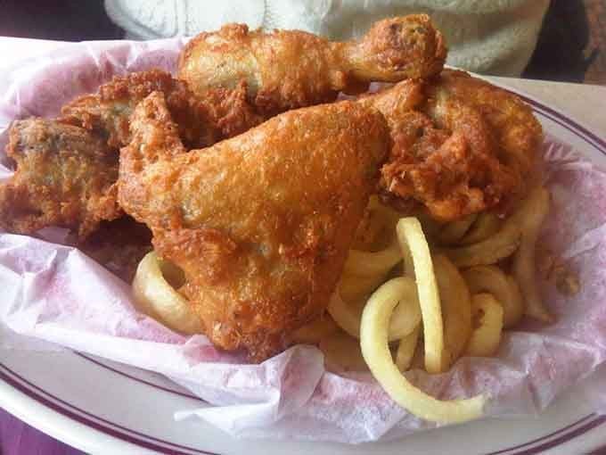 Golden fried chicken piled high over curly fries looks like something your favorite aunt would make, if she could fry like this.