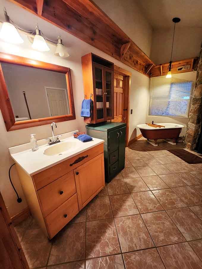 A bathroom featuring a clawfoot tub because sometimes you need to soak under exposed beams like royalty.