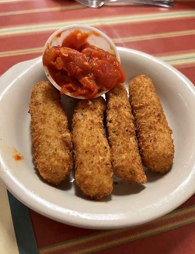 Golden, crispy mozzarella sticks that stretch like they're auditioning for a cheese commercial, marinara sauce included for dunking.
