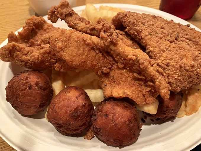 Golden fried flounder with hush puppies so perfectly crispy, they could make a seafood skeptic reconsider their entire life philosophy.