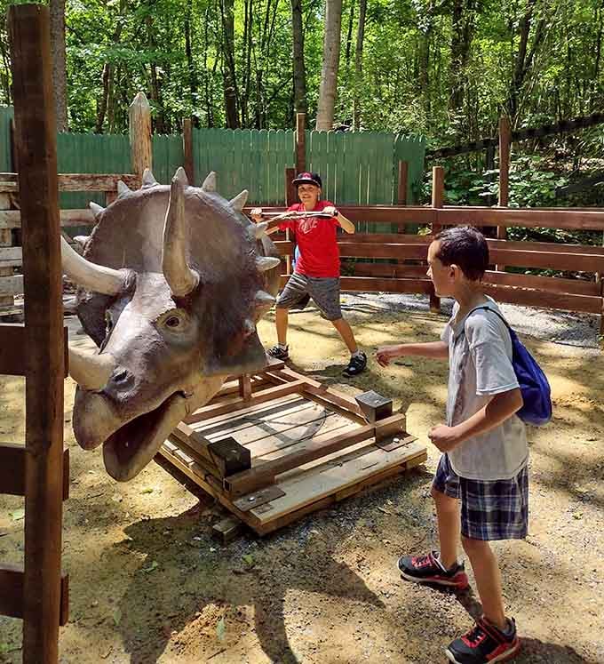 Young adventurers discover that triceratops make surprisingly cooperative photo partners, even when mounted on wooden platforms in summer sunshine.