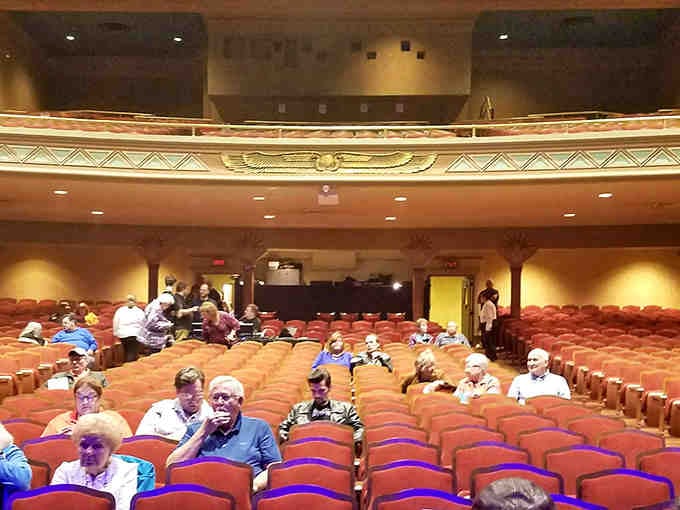 Real people settling into plush seats, ready for magic to unfold in this atmospheric wonder.