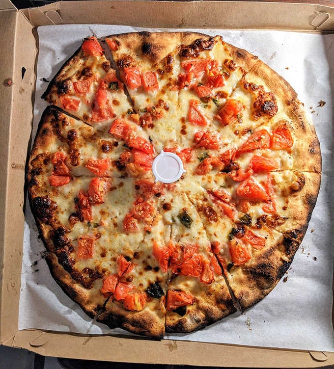 Fresh tomatoes on pizza might sound simple until you taste how summer sunshine translates into pure, unadulterated deliciousness.