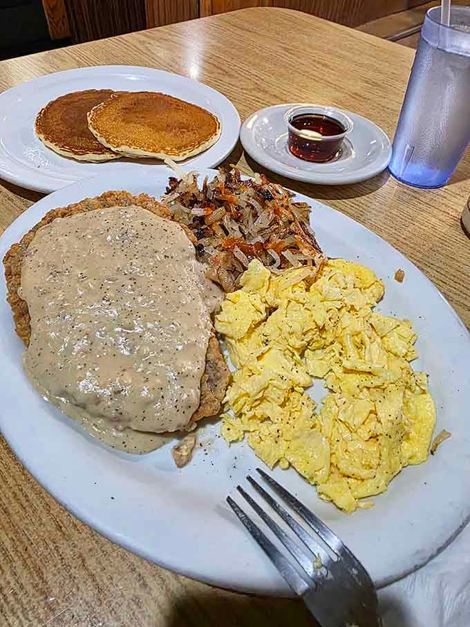 Country fried steak smothered in gravy alongside fluffy scrambled eggs, hash browns, and pancakes, this plate means serious business.
