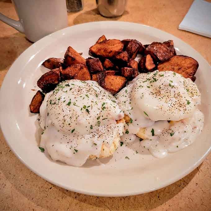 Eggs Benedict with home fries that actually have crispy edges, proving breakfast doesn't have to choose between fancy and satisfying.