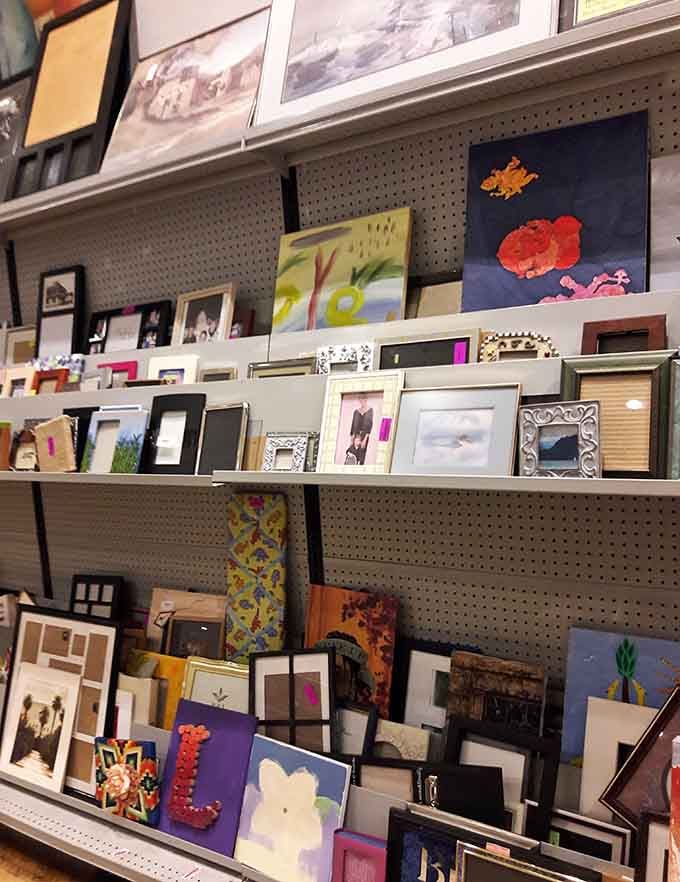 Picture frames and artwork stacked like a museum gift shop exploded in the best possible way, waiting for discovery.