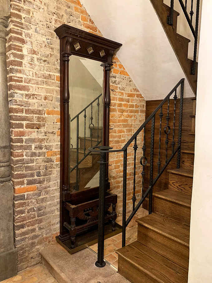 An ornate mirror flanked by weathered brick reminds you that history and beauty make excellent roommates here.