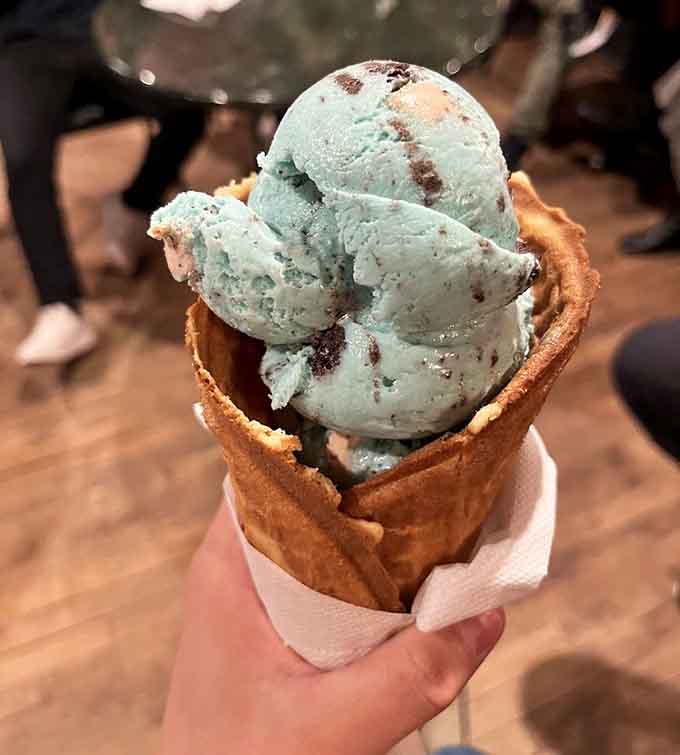 Mint chocolate chip in a waffle cone, stacked high like an edible tower of pure summer joy and happiness.