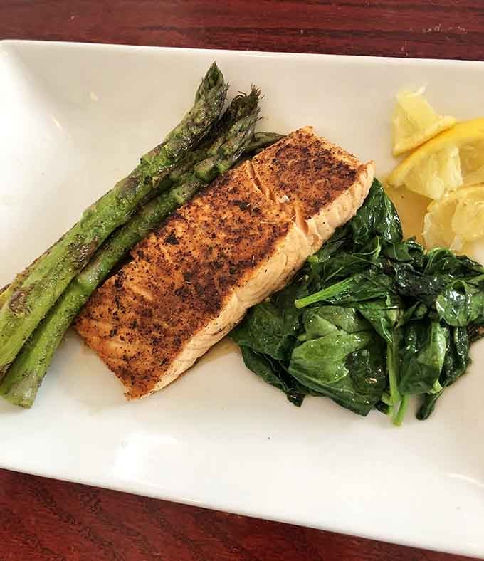 Blackened salmon sitting pretty on a bed of spinach proves this kitchen doesn't play favorites with proteins.