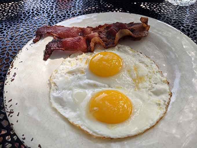 Perfectly cooked eggs with bacon that's actually crispy, proving some restaurants still respect the breakfast fundamentals that matter most.