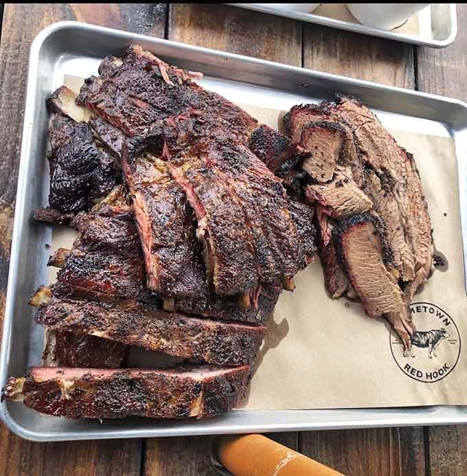 A metal tray loaded with beef ribs and brisket proves that heaven exists and it's made of smoke.