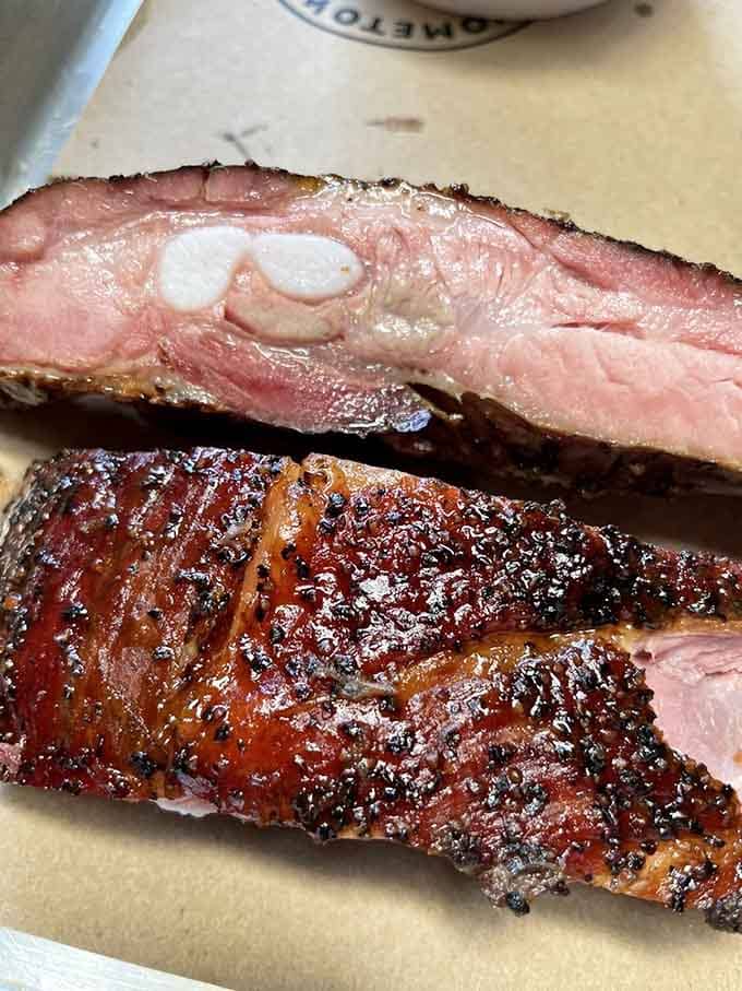Those spare ribs showcase a smoke ring so pink it looks like a sunset trapped in meat form.