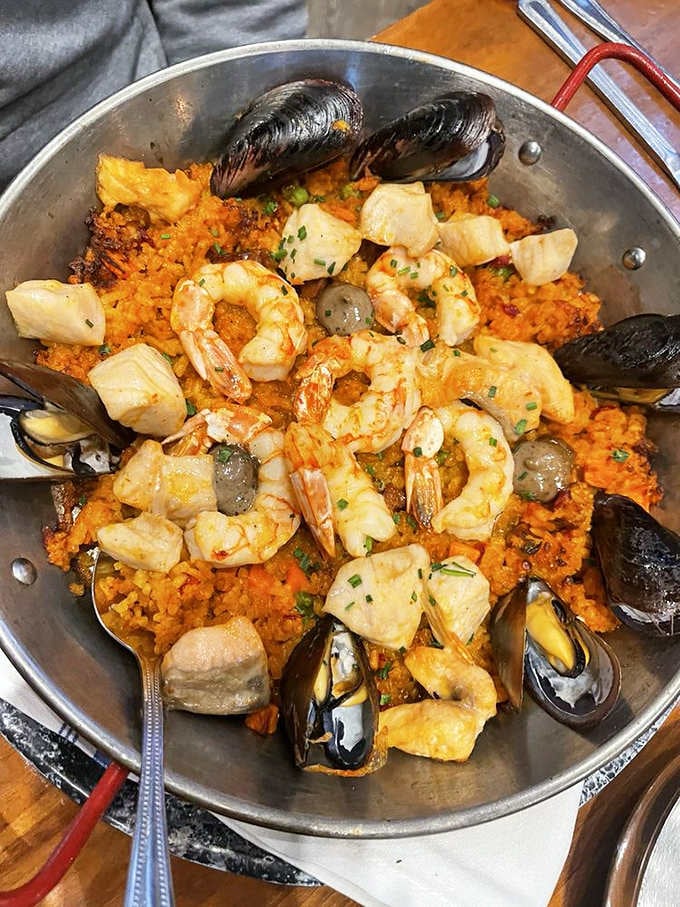 Seafood paella in a pan big enough to bathe a small dog, loaded with treasures from the deep blue sea.