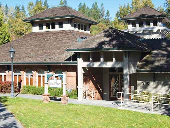 Jacksonville Library stands surrounded by autumn leaves, looking like every cozy reading fantasy you've ever had come true.