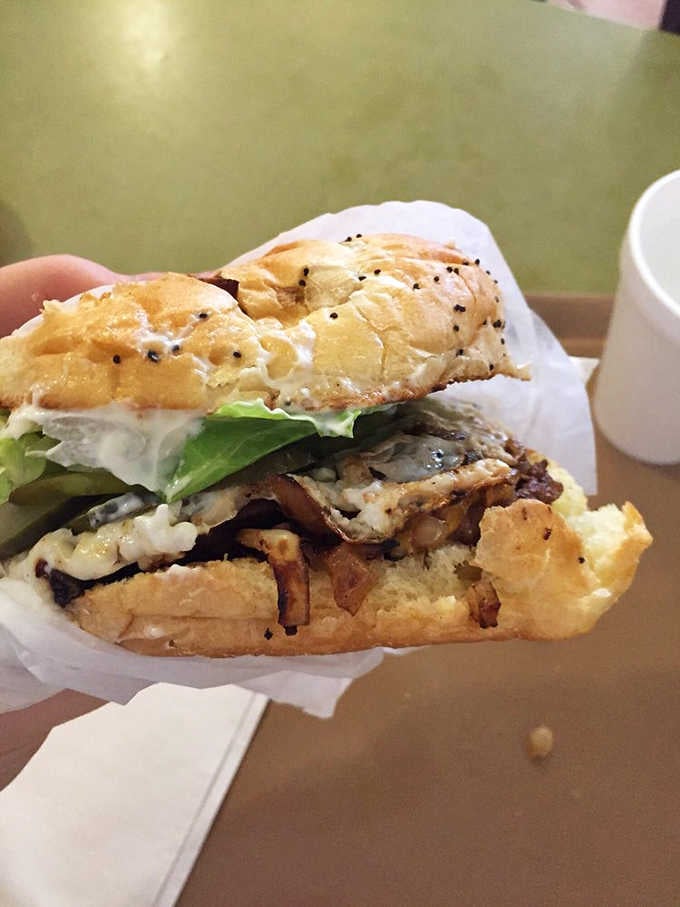 This towering masterpiece of beef, cheese, and grilled onions requires both hands and a strategy that would impress a chess grandmaster.