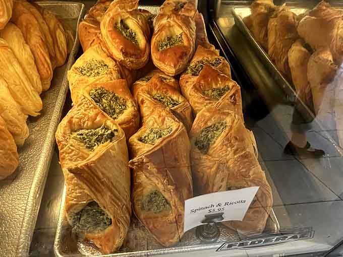 Golden spinach and ricotta pastries gleaming in the case, each one a flaky, savory masterpiece waiting to happen.