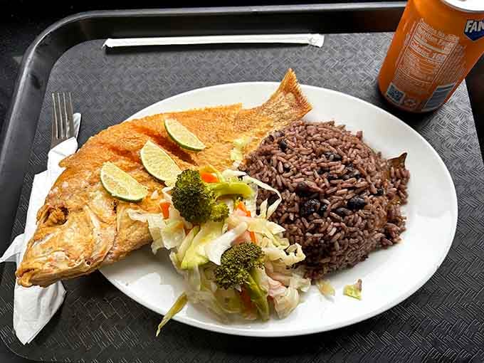 Whole fried fish served with rice and vegetables, proving simple done right beats fancy done wrong.