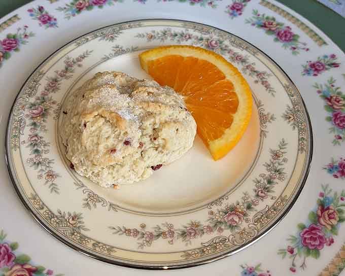 A proper scone with a fresh orange slice proves that simple elegance never goes out of style.