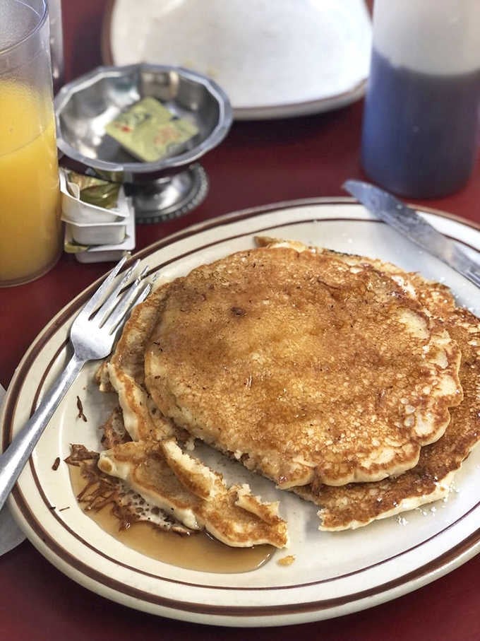 Golden pancakes stacked high with butter melting down the sides like a delicious avalanche of happiness.