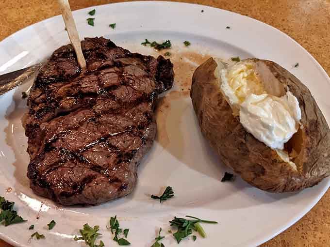 Perfectly grilled ribeye paired with a fluffy baked potato, simple pleasures executed with serious skill and care.