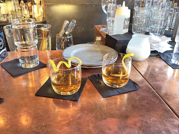 Two whiskeys with citrus twists waiting at the bar, because sometimes life's best decisions come in pairs.