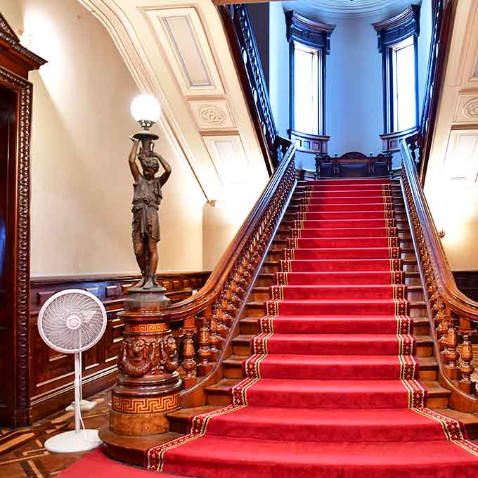 That red carpet practically begs you to descend like you're accepting an award for Best Dressed Victorian Guest.