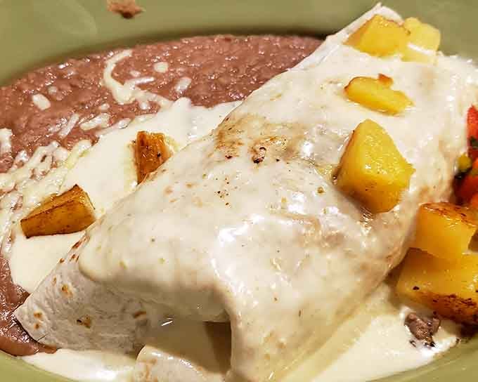When a burrito gets smothered in white cheese sauce like this, you know someone in that kitchen really understands comfort food.