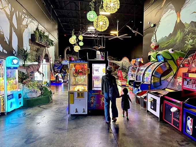Arcade games glow under atmospheric lighting while families wander through, deciding which adventure to tackle next here.