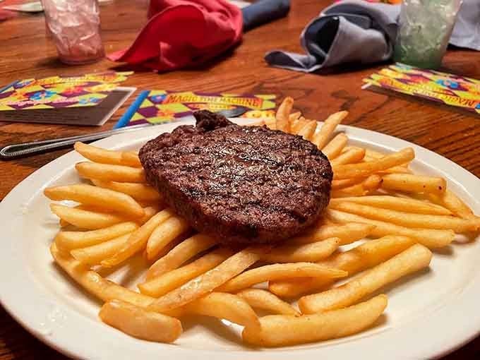 A hamburger steak surrounded by golden fries like they're protecting something precious, which they absolutely are.