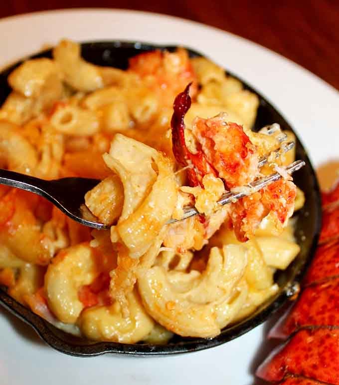 Lobster mac and cheese in a cast iron skillet is comfort food that went to finishing school and came back fancy.