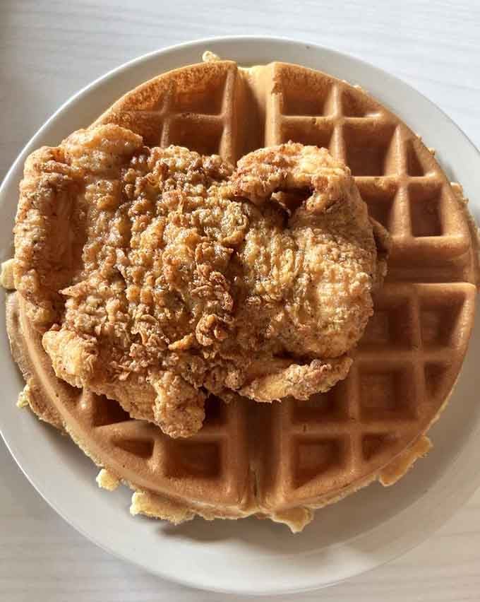 Crispy fried chicken perched on a golden waffle is the kind of culinary genius that makes you question every breakfast choice you've ever made.