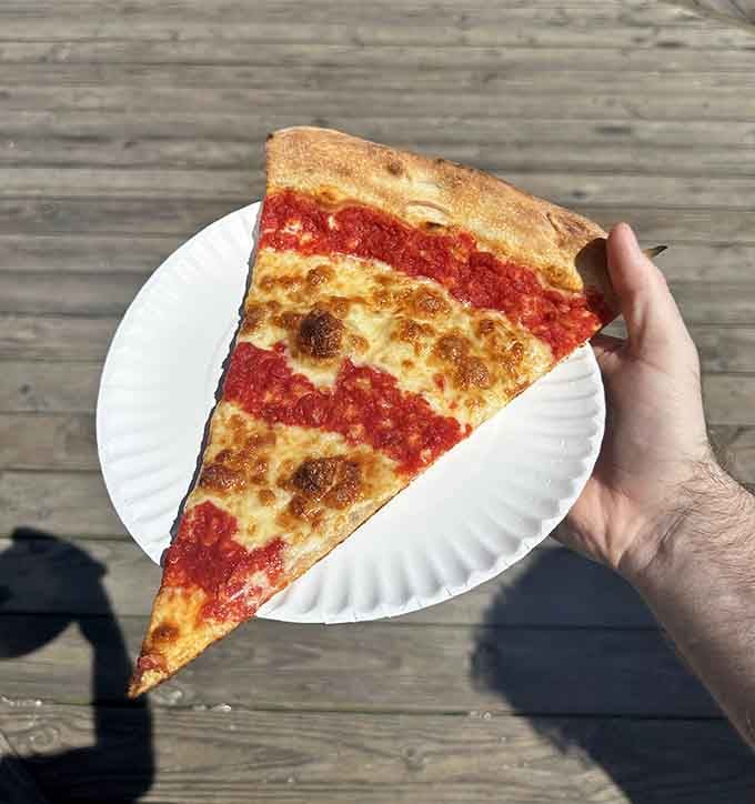 Behold the perfect slice: sauce-forward, cheese-blessed, and ready to make your taste buds sing the hallelujah chorus.