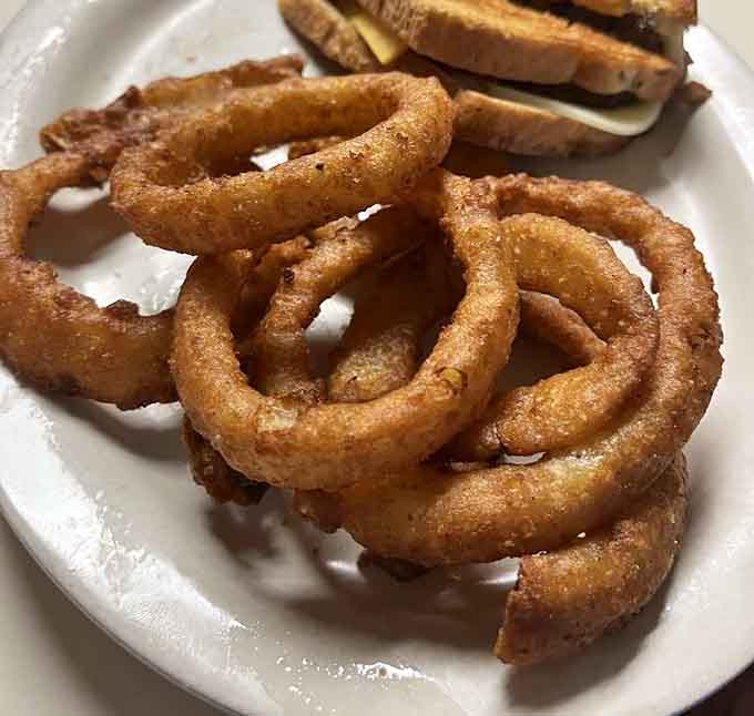 Onion rings fried to crispy perfection, each golden circle a testament to the simple joy of doing classics exceptionally well.