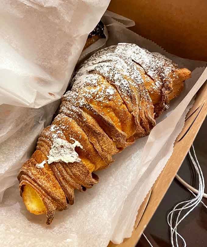 The lobster tail pastry towers like a flaky, cream-filled skyscraper that demands your immediate attention and appetite.